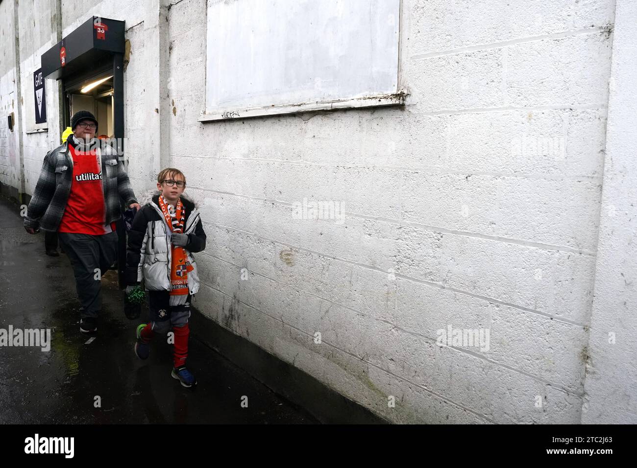 Luton Town fans make their way to the stadium as it rains before the ...