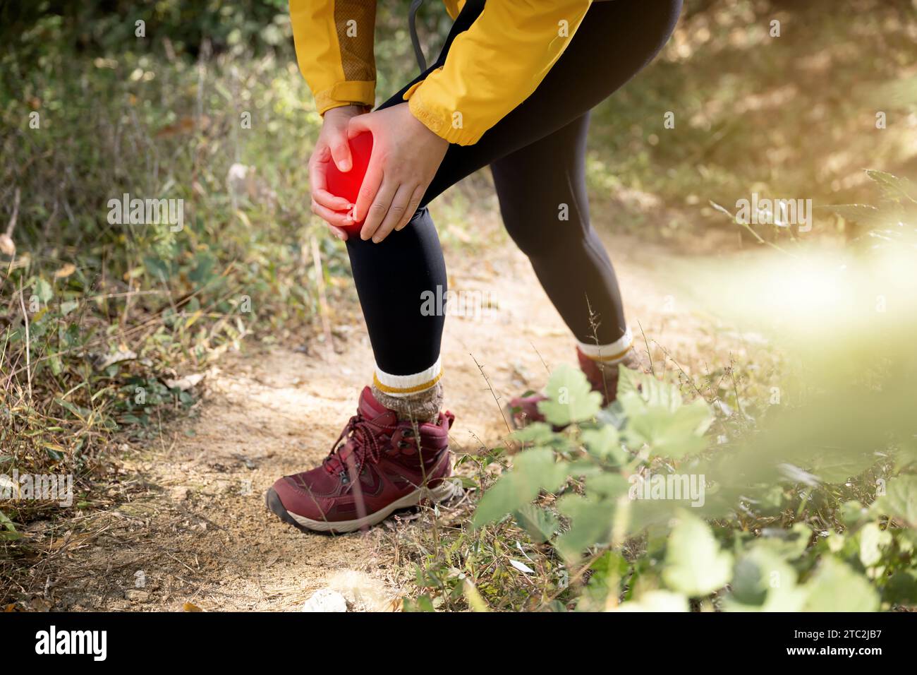 A woman is holding her knee joint in excruciating pain at uphill road ...