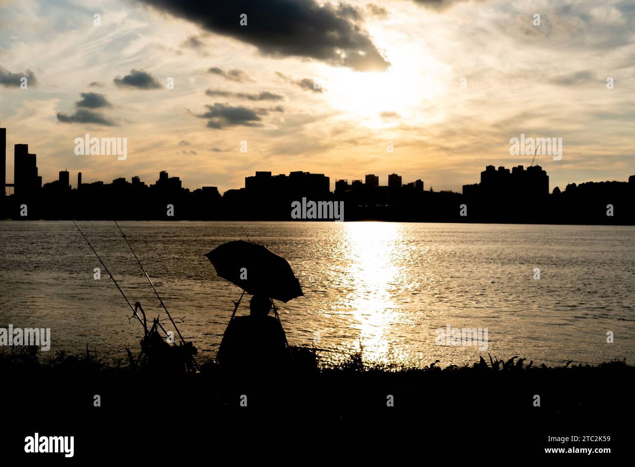 Silhouette of a man, fishing at Han River with the sunsets and view of ...