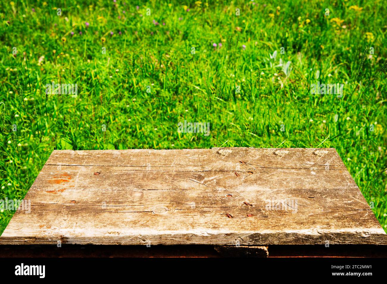 empty old brown table on green grass background Stock Photo - Alamy