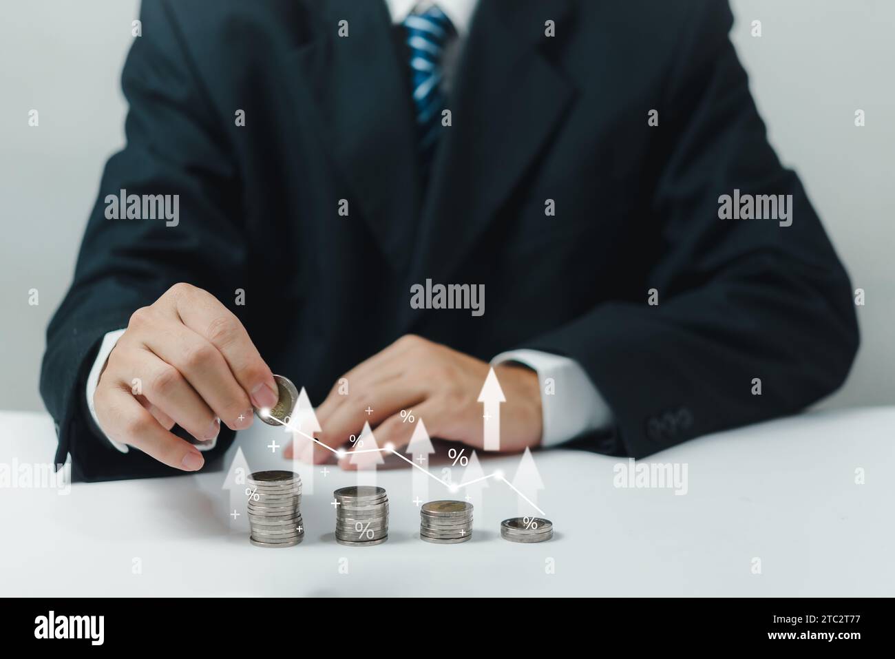 Businessman stacking coins with an upward arrow symbolizes financial ...