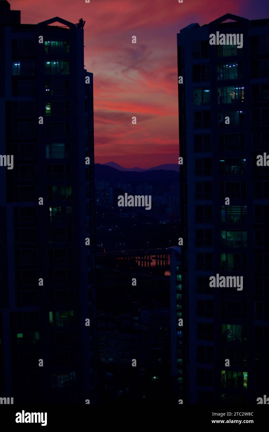 Ulsan's skyline at sunset, with dark apartment silhouettes, vibrant sky ...
