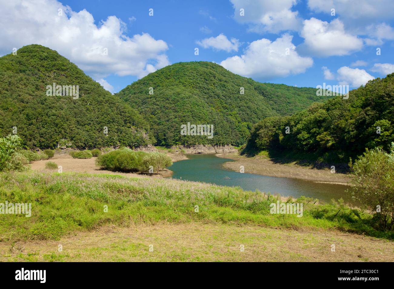 A picturesque landscape unfolds, featuring conical shaped mountains, a ...