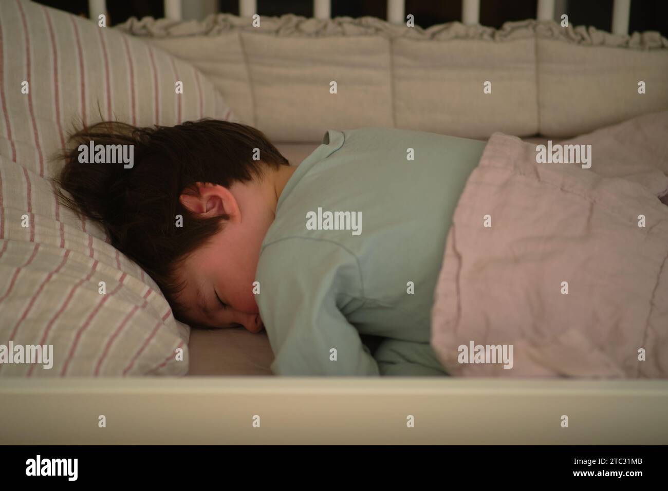 Baby boy sleeps in a crib and tosses, kid age two years and five months ...