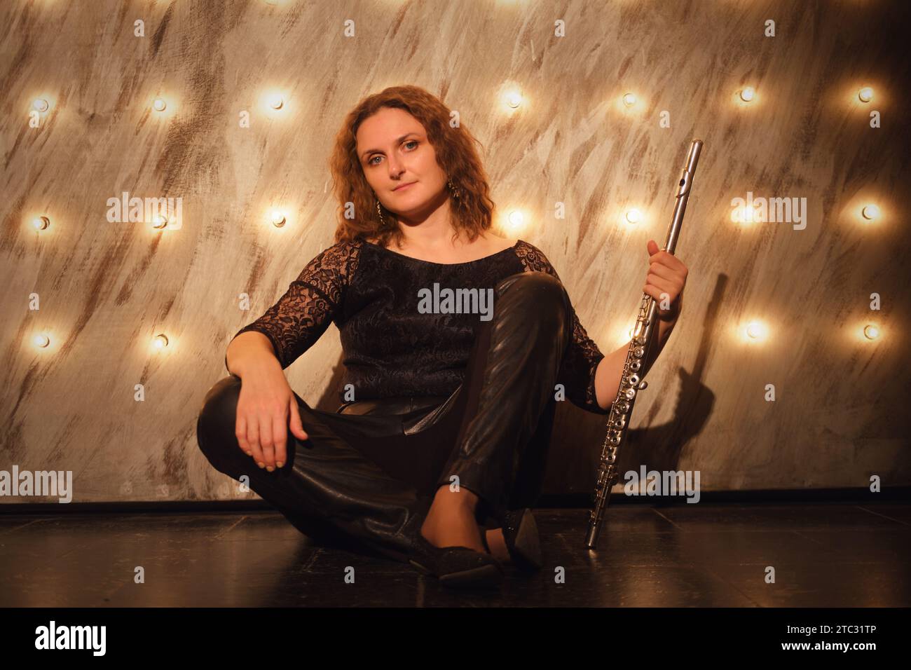 The flutist, a female musician, played her instrument under the bright ...