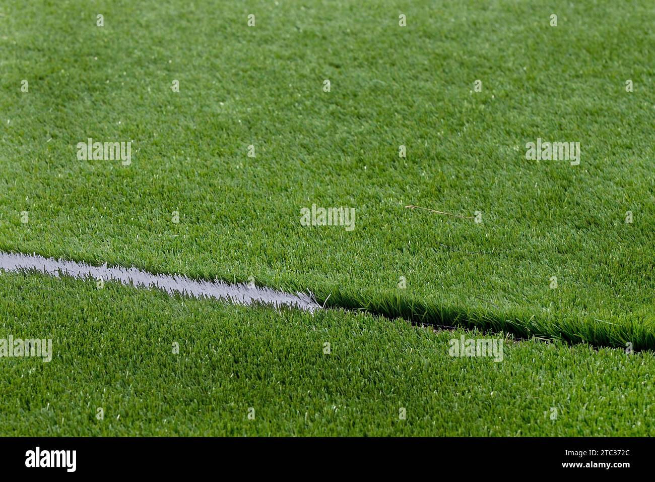 Closeup installation of football field with artificial turf with grass ...