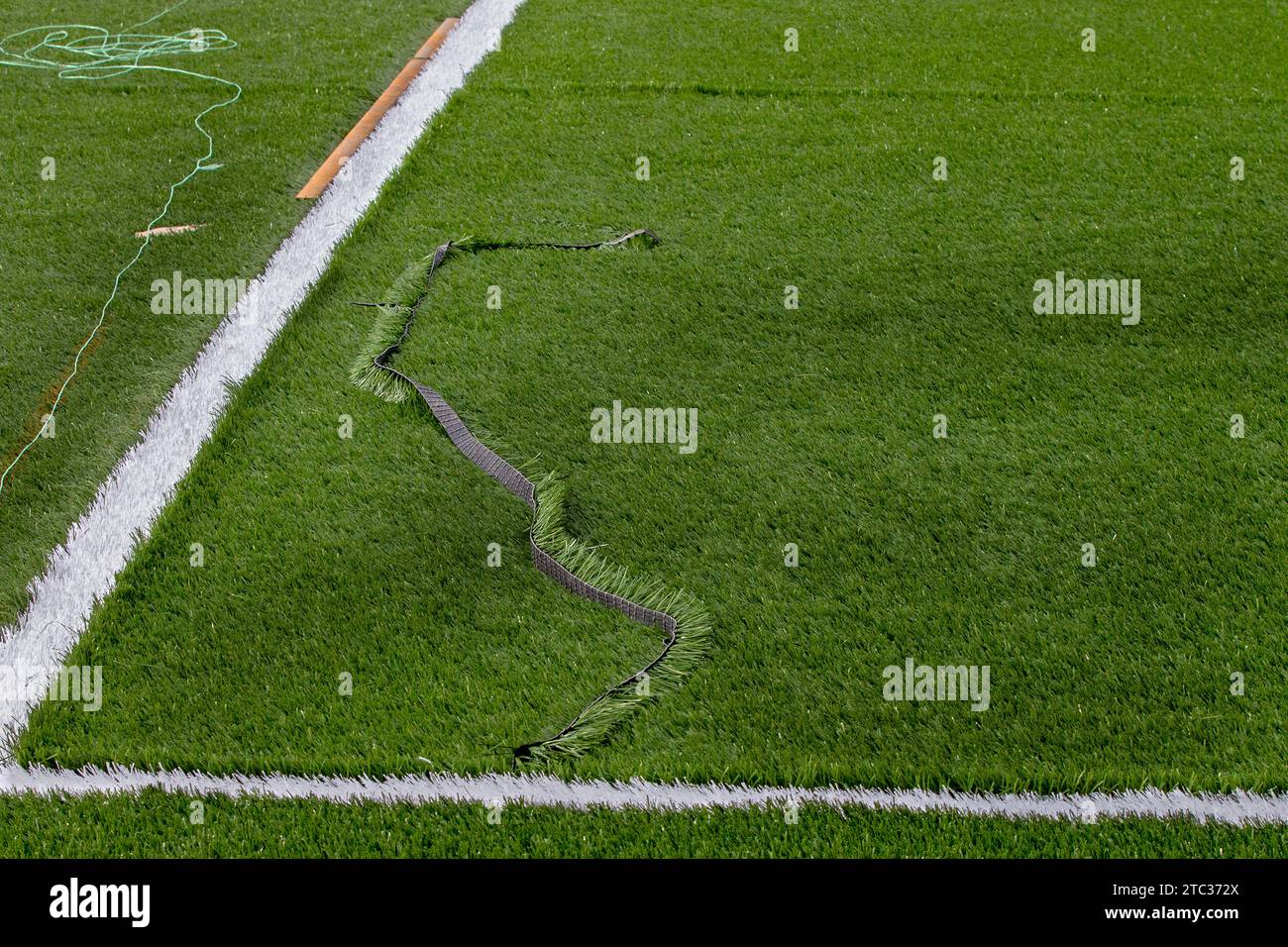 Closeup installation of football field with artificial turf with grass ...