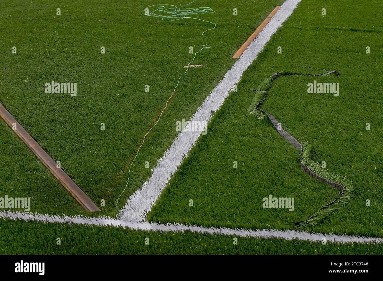 Closeup installation of football field with artificial turf with grass ...