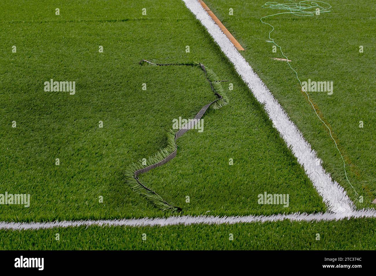 Closeup installation of football field with artificial turf with grass ...