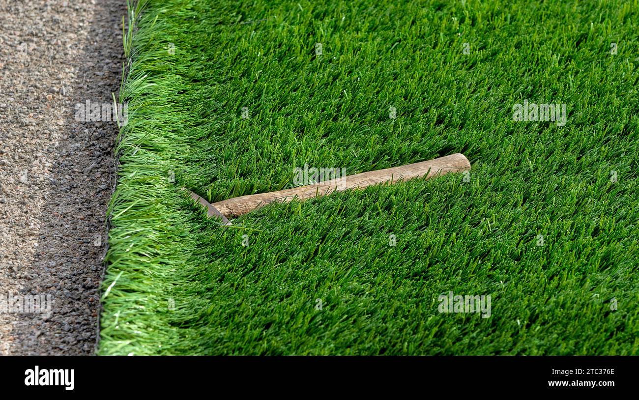 Closeup installation of football field with artificial turf with grass ...