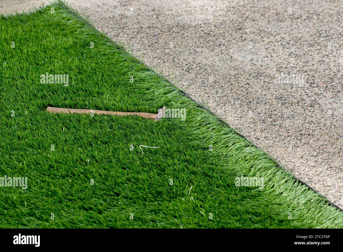 Closeup installation of football field with artificial turf with grass ...