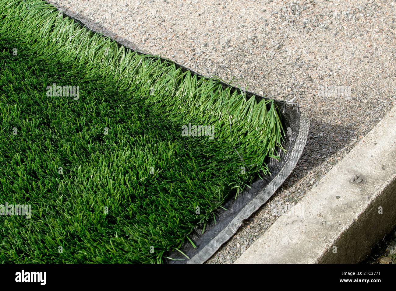 Closeup installation of football field with artificial turf with grass ...