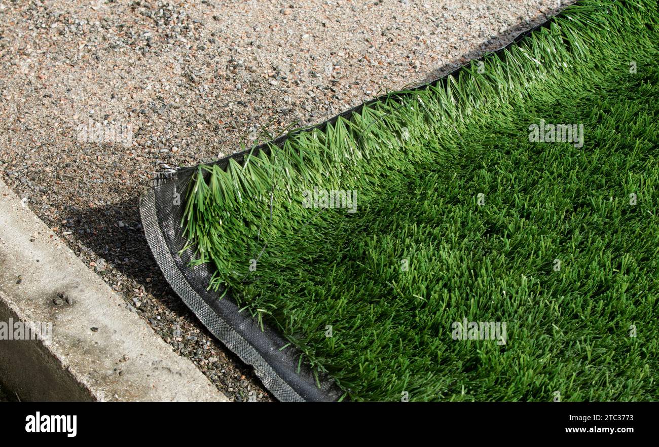 Closeup installation of football field with artificial turf with grass ...