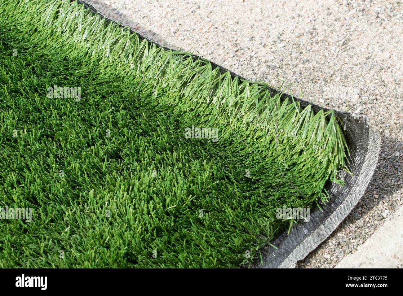 Closeup installation of football field with artificial turf with grass ...