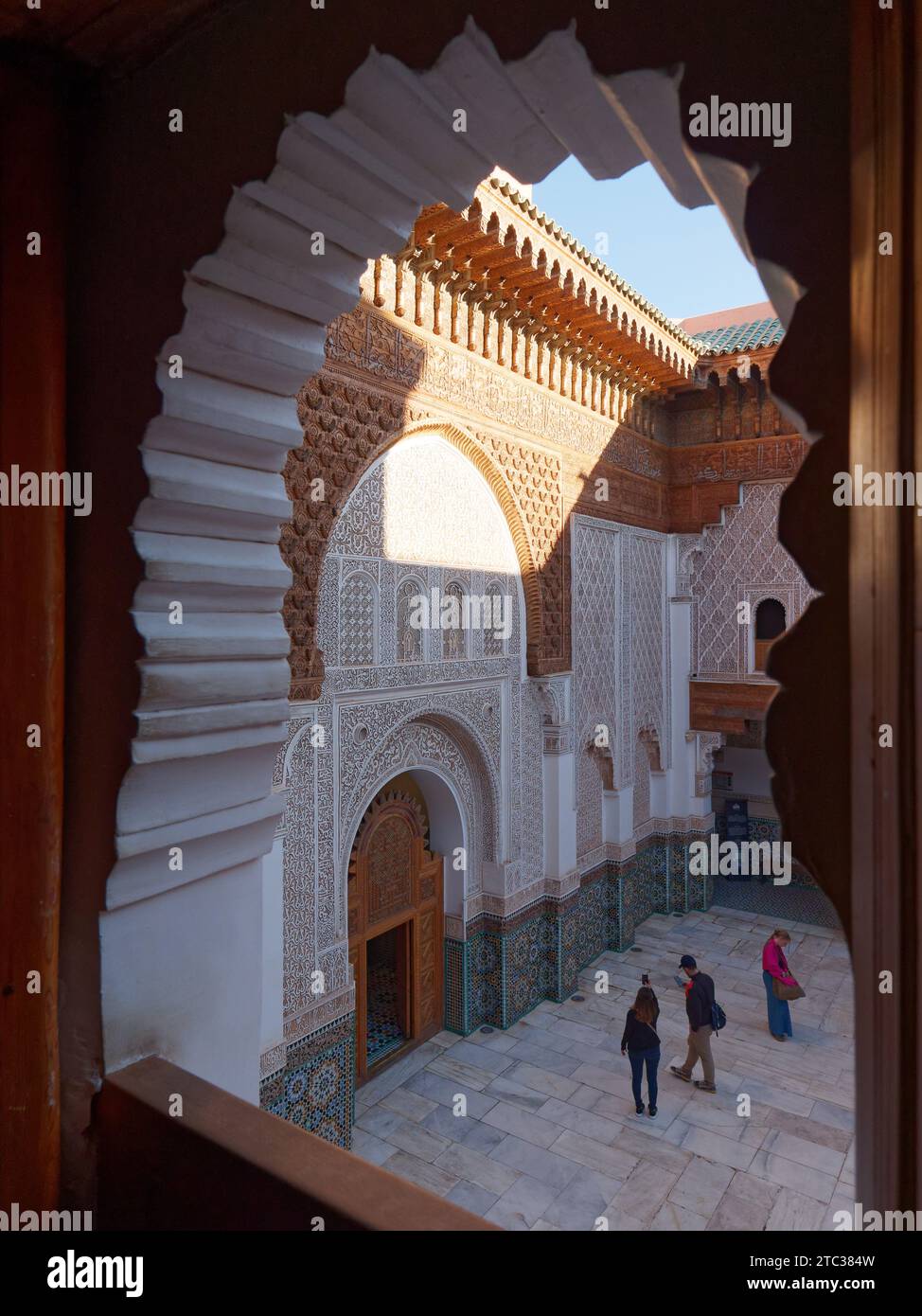 Tourists in the courtyard at Ben Youssef Medersa historic Islamic school/college in Marrakesh ...