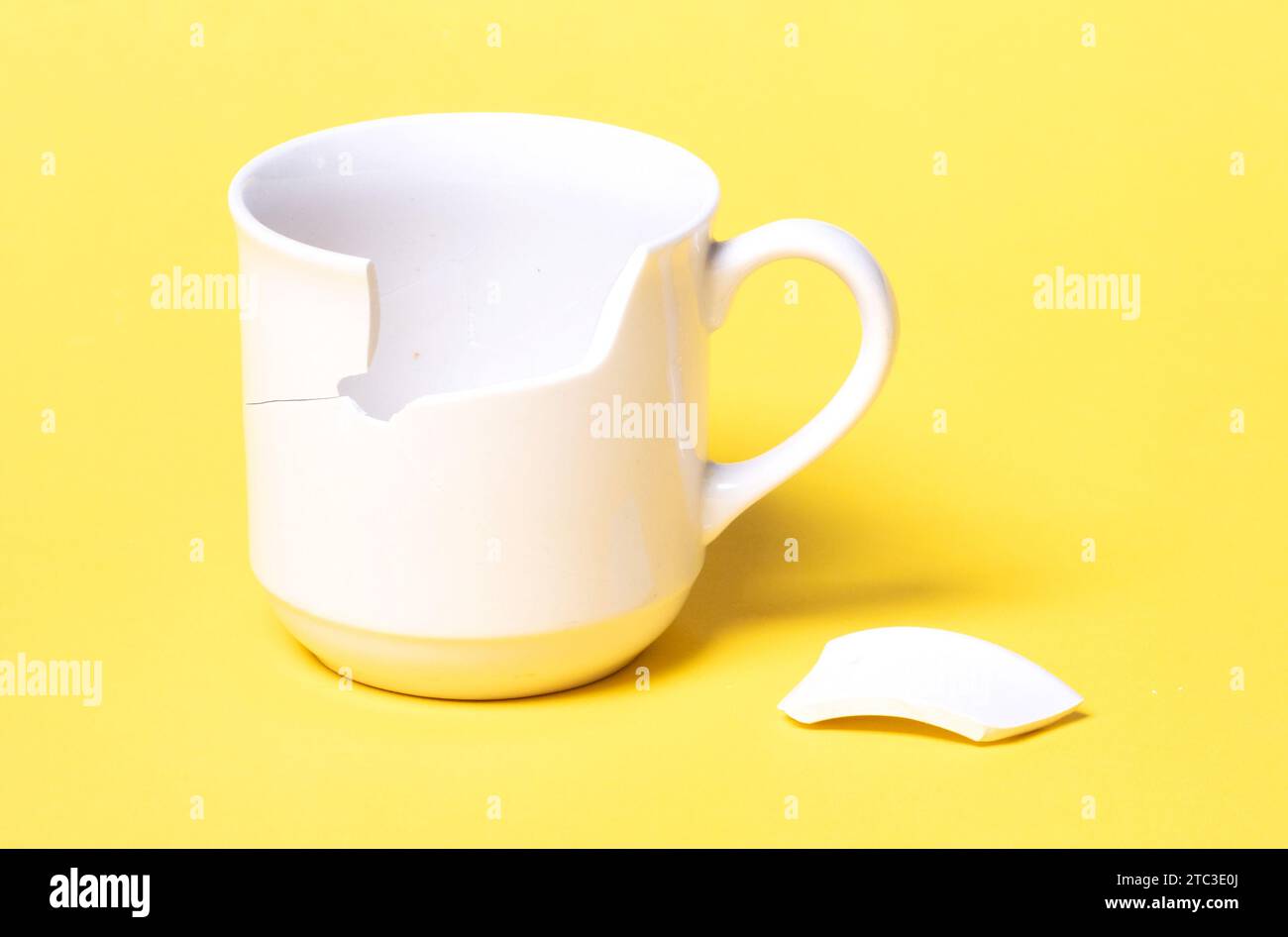Broken cup isolated on a solid yellow background Stock Photo - Alamy