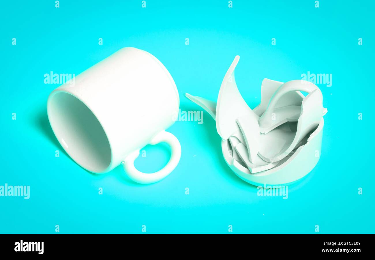 Broken cup isolated on a solid blue background Stock Photo - Alamy