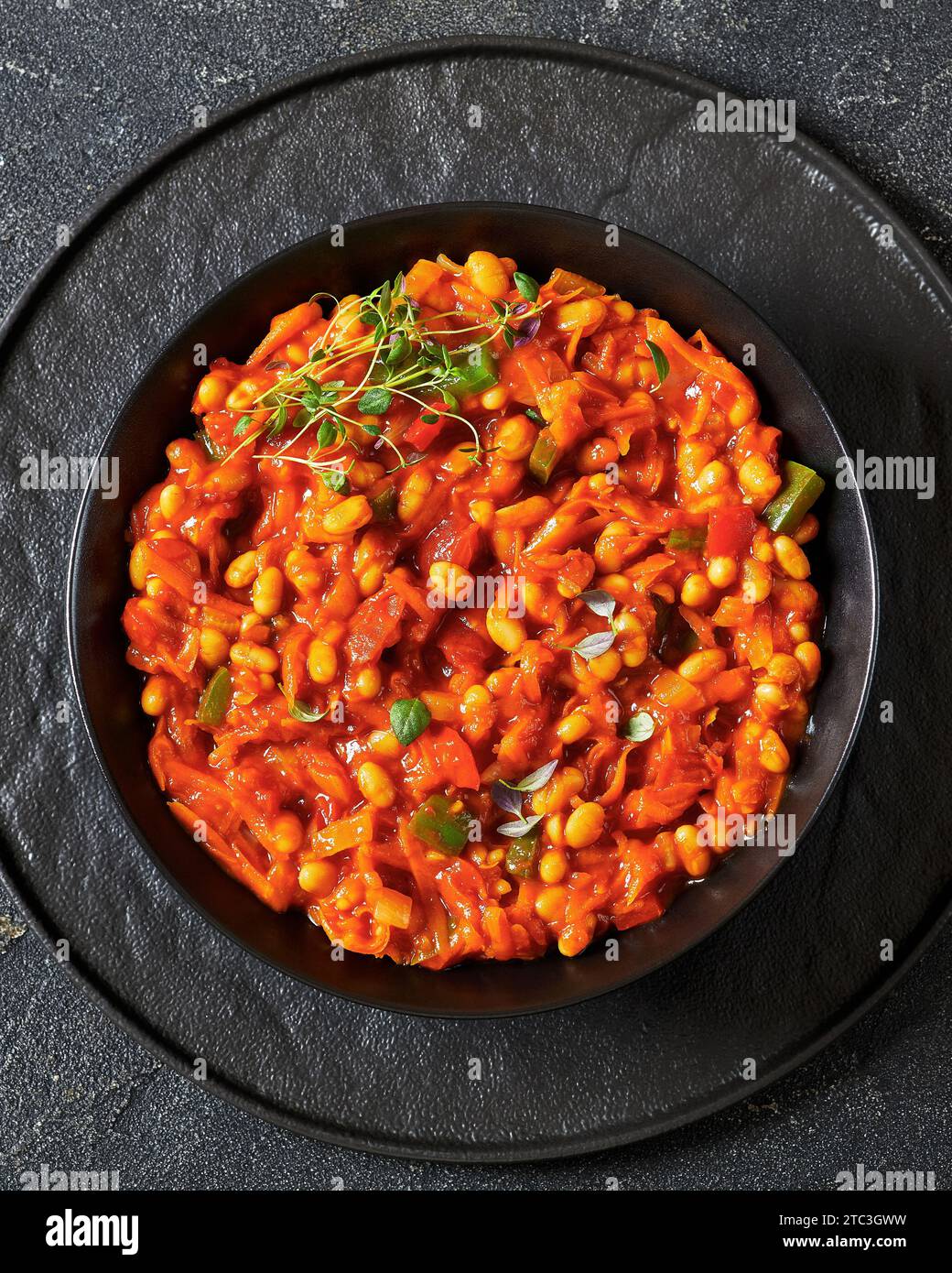 chakalaka, refreshing spicy tomato bean relish in black bowl on grey ...