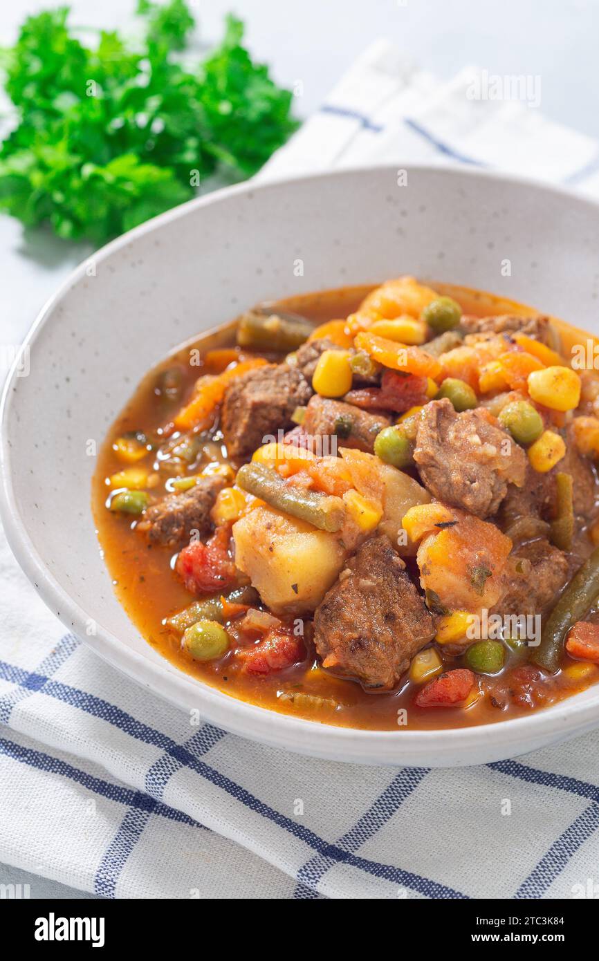 Beef stew with potato, green beans, carrot, celery, peas and corn, in ...