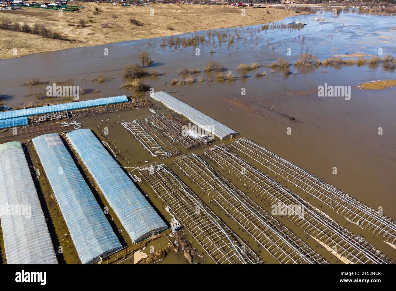 Aerial view of farm greenhouses flooded during the spring flood, severe ...