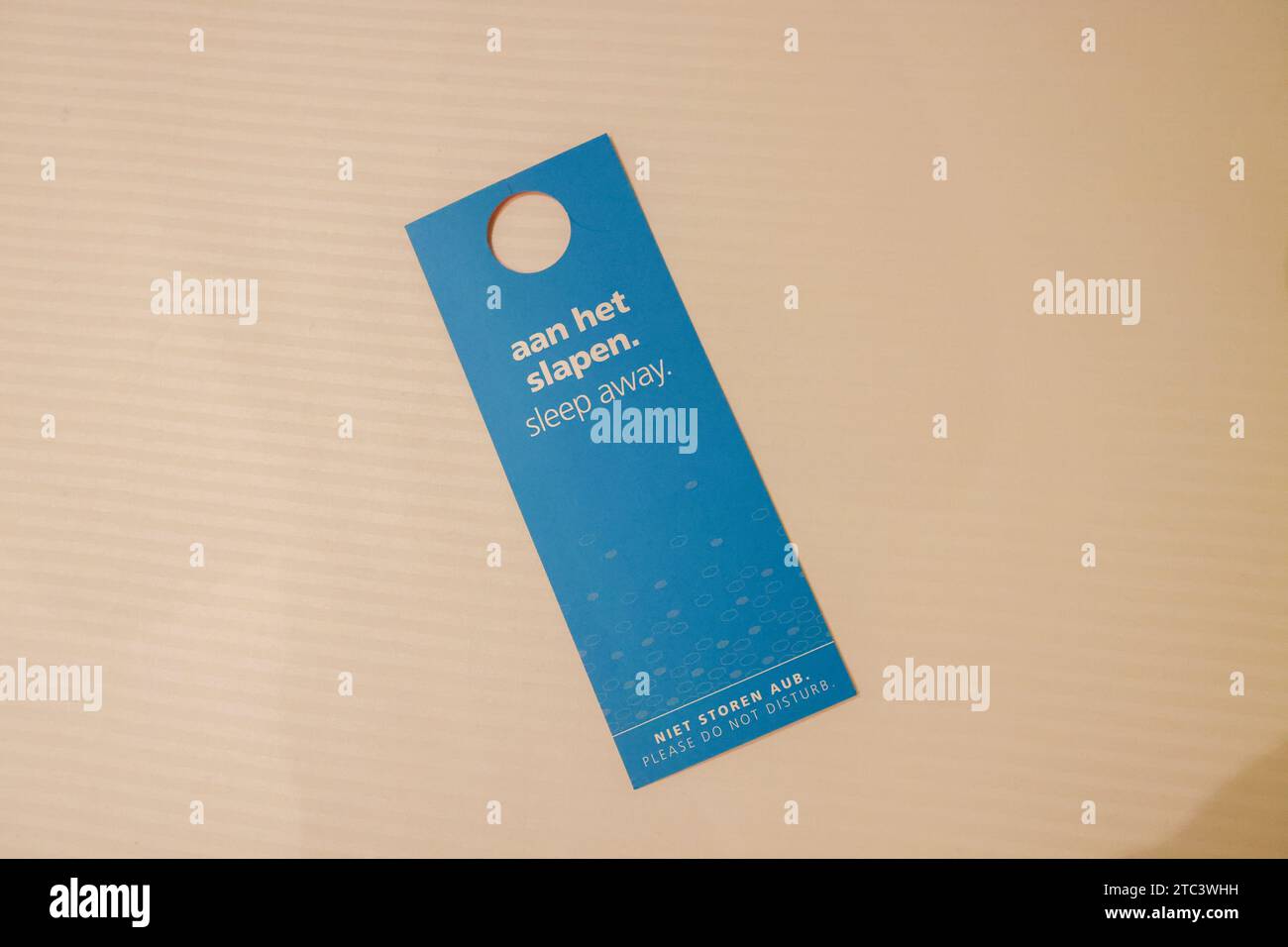 Blue Do-not-disturb sign with text "Aan het slapen- Sleep away" on a ...