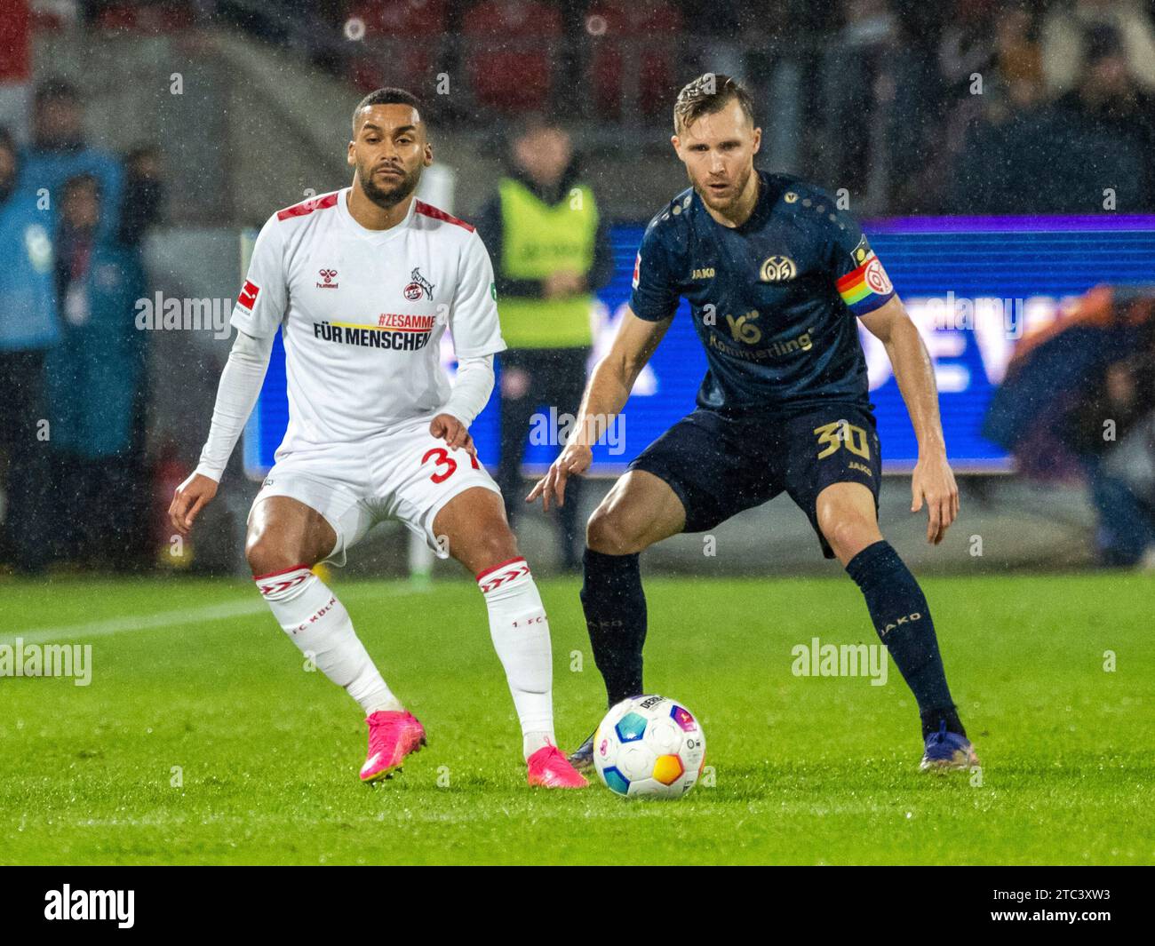 Koeln, Deutschland. 10th Dec, 2023. Linton Maina (1. FC Koeln, #37), Silvan Widmer (1. FSV Mainz ...