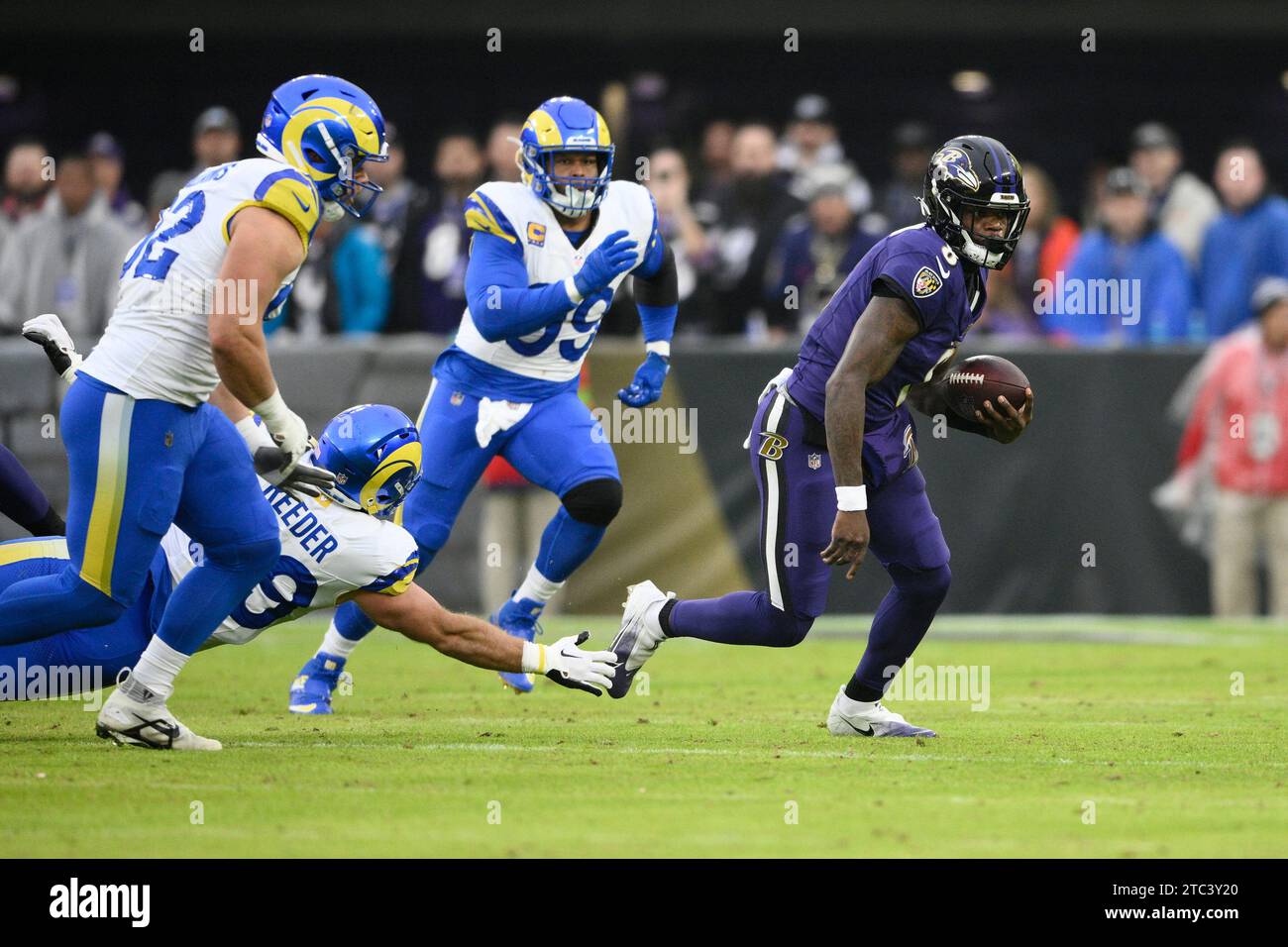 Baltimore Ravens quarterback Lamar Jackson, right, gets past Los ...