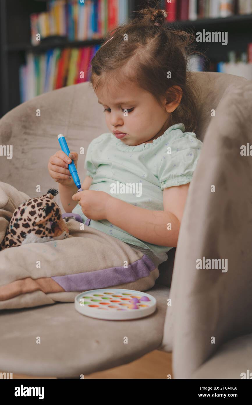 Adorable small baby toddler playing with blue color marker indoors at ...