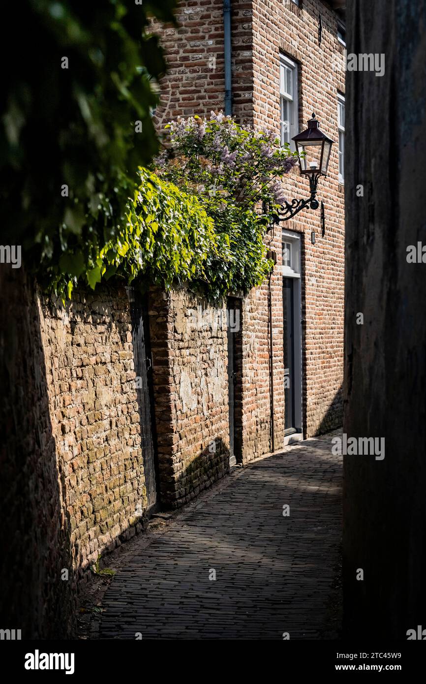 Narrow street inside old dutch town with curvature so you can't see the ...