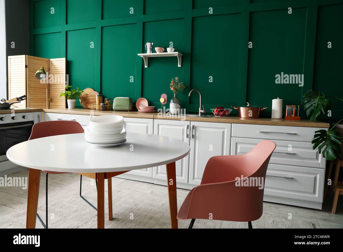 Interior of modern kitchen with white counters and dining table Stock ...