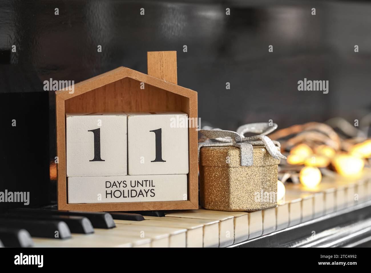 Calendar with text 11 DAYS UNTIL HOLIDAYS and Christmas decor on piano ...