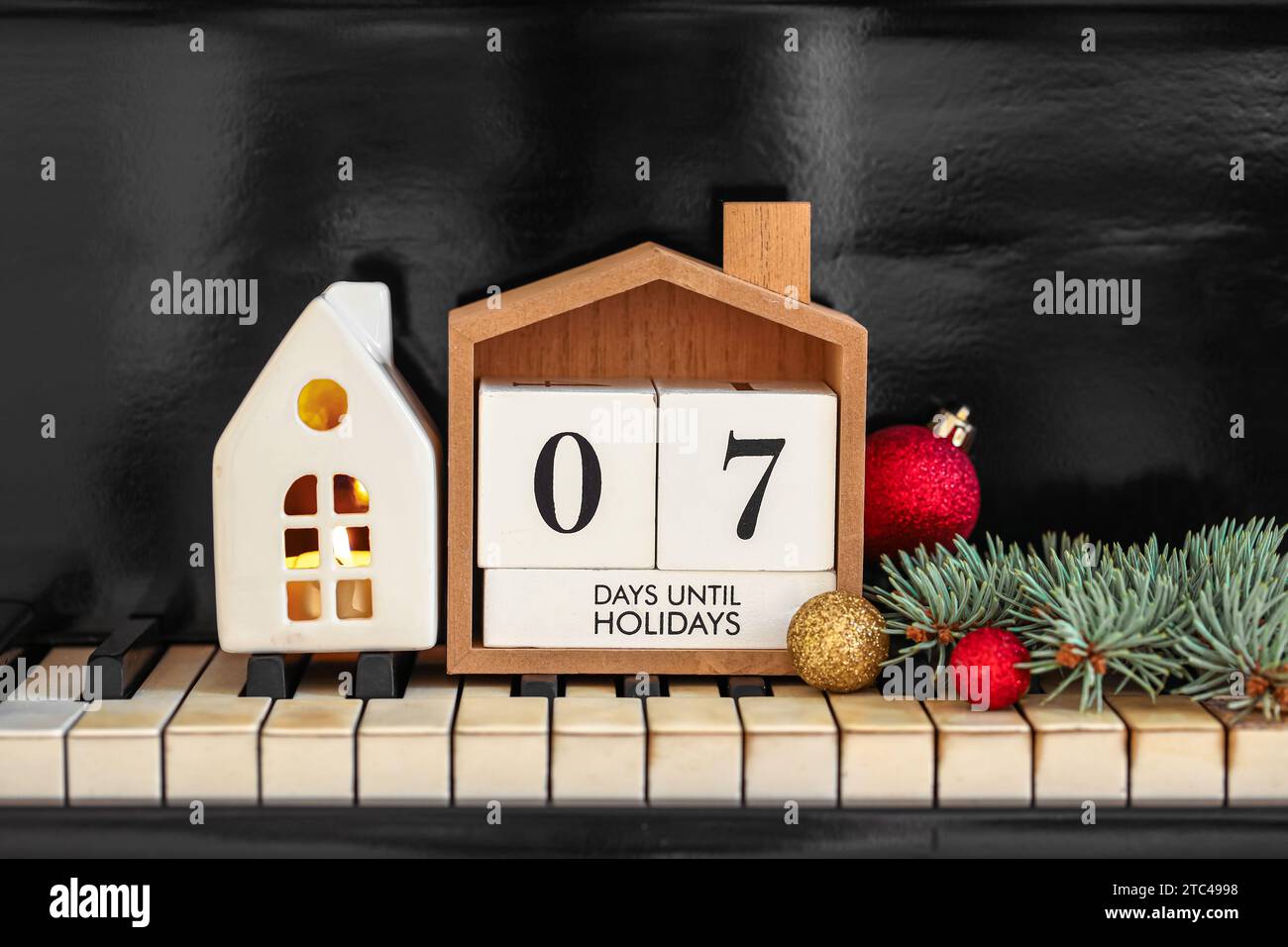 Calendar with text 7 DAYS UNTIL HOLIDAYS and Christmas decor on piano ...