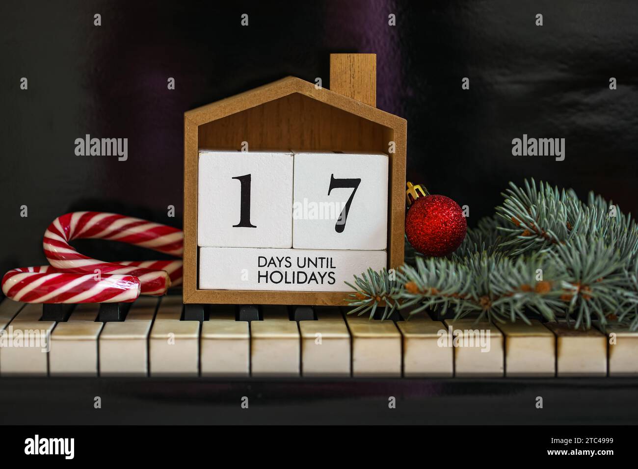 Calendar with text 17 DAYS UNTIL HOLIDAYS, candy canes and fir branches ...