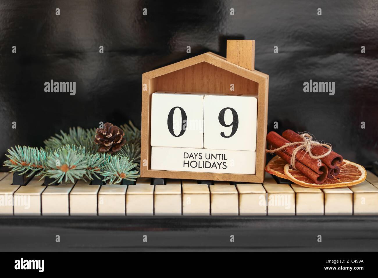 Calendar with text 9 DAYS UNTIL HOLIDAYS and Christmas decor on piano ...