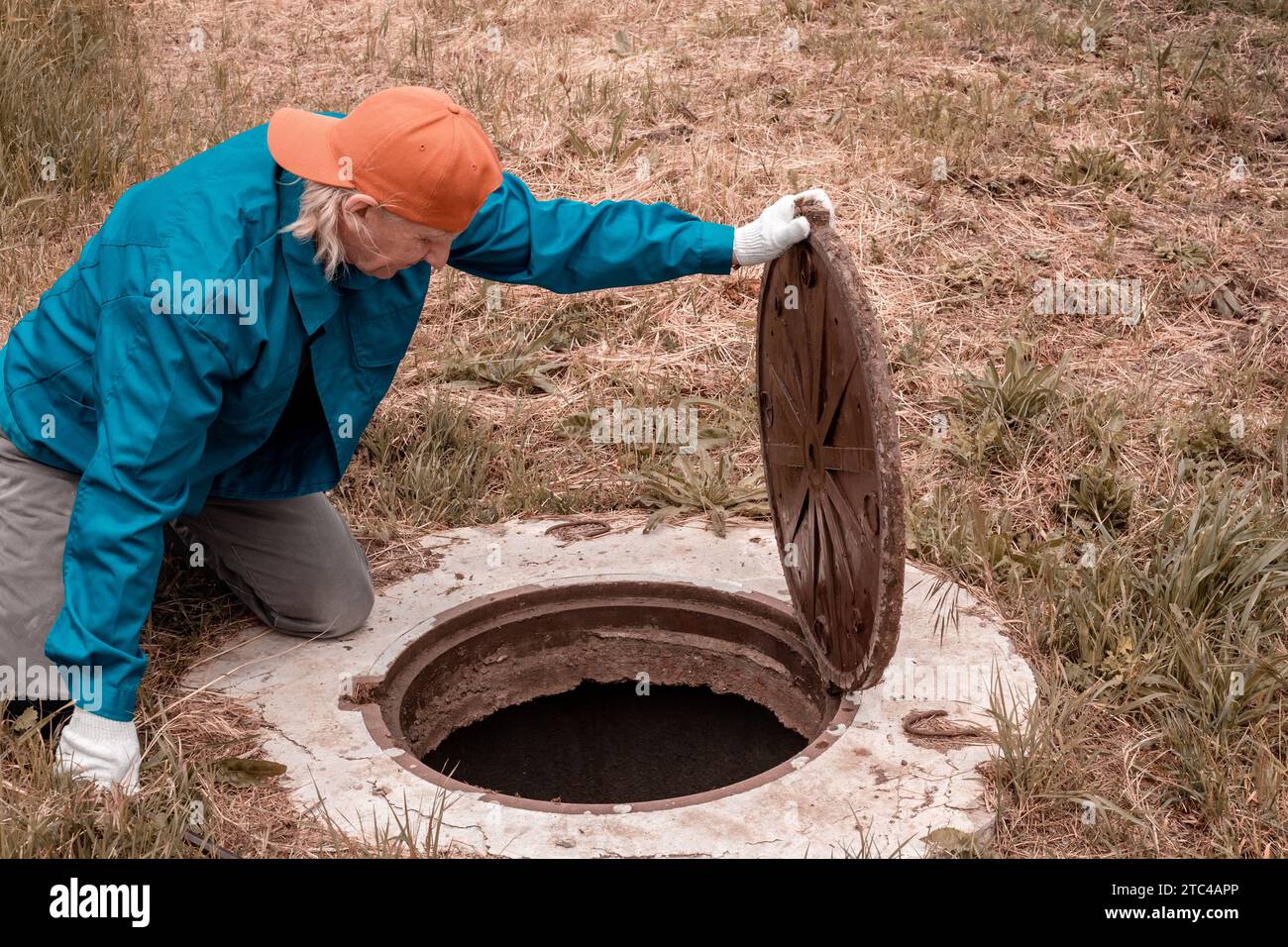 The worker opened the well hatch and looks inside. Troubleshooting ...