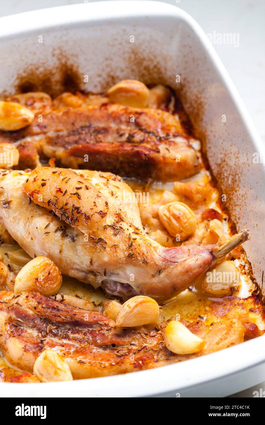baked rabbit leg with garlic and bacon Stock Photo - Alamy