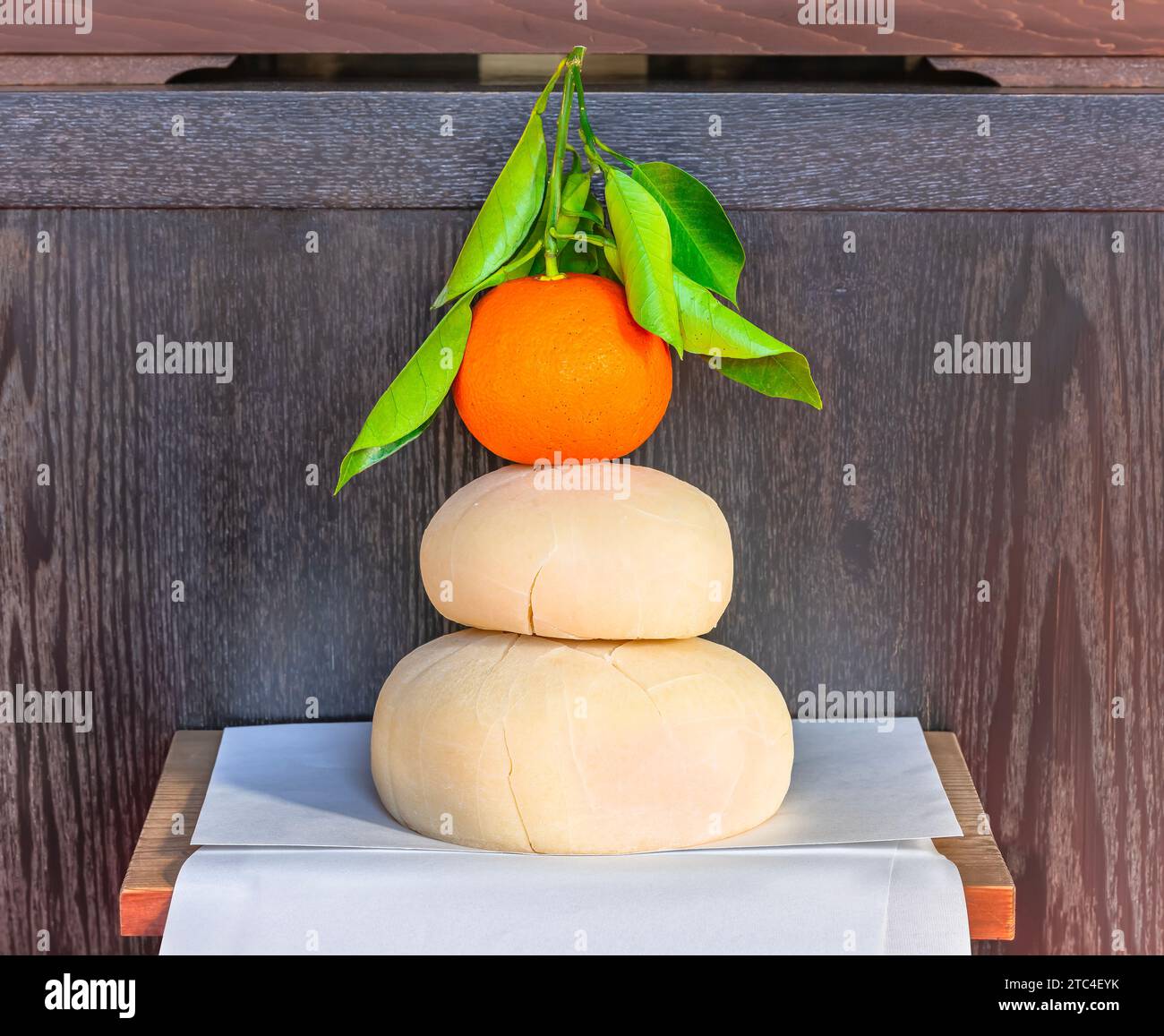 Traditional Japanese New Year decoration Kagami Mochi with two stacked rice cakes topped with a ...
