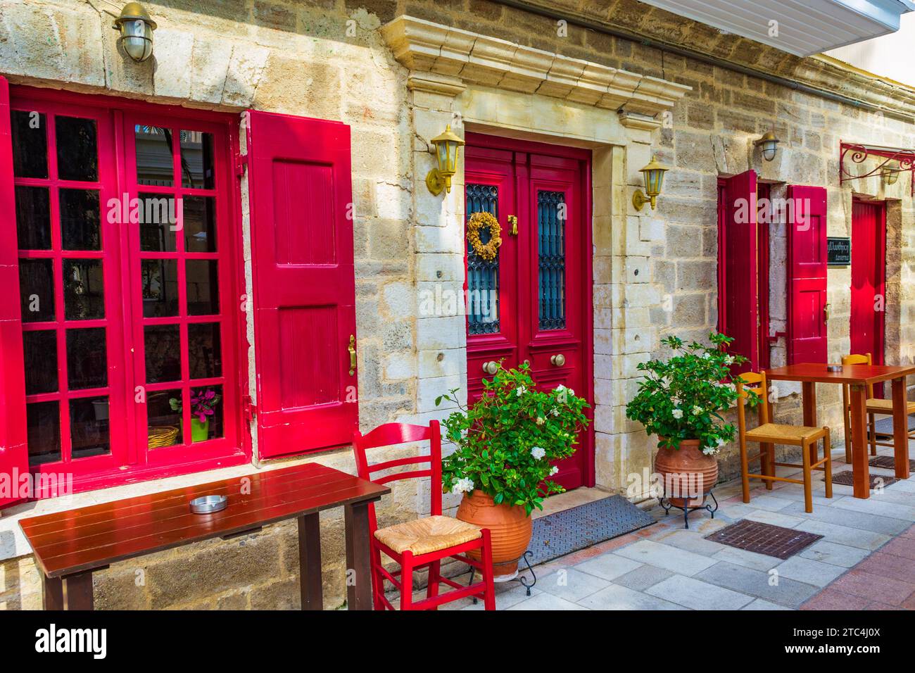 Red front door and window shutters of typical Greek island tavern ...