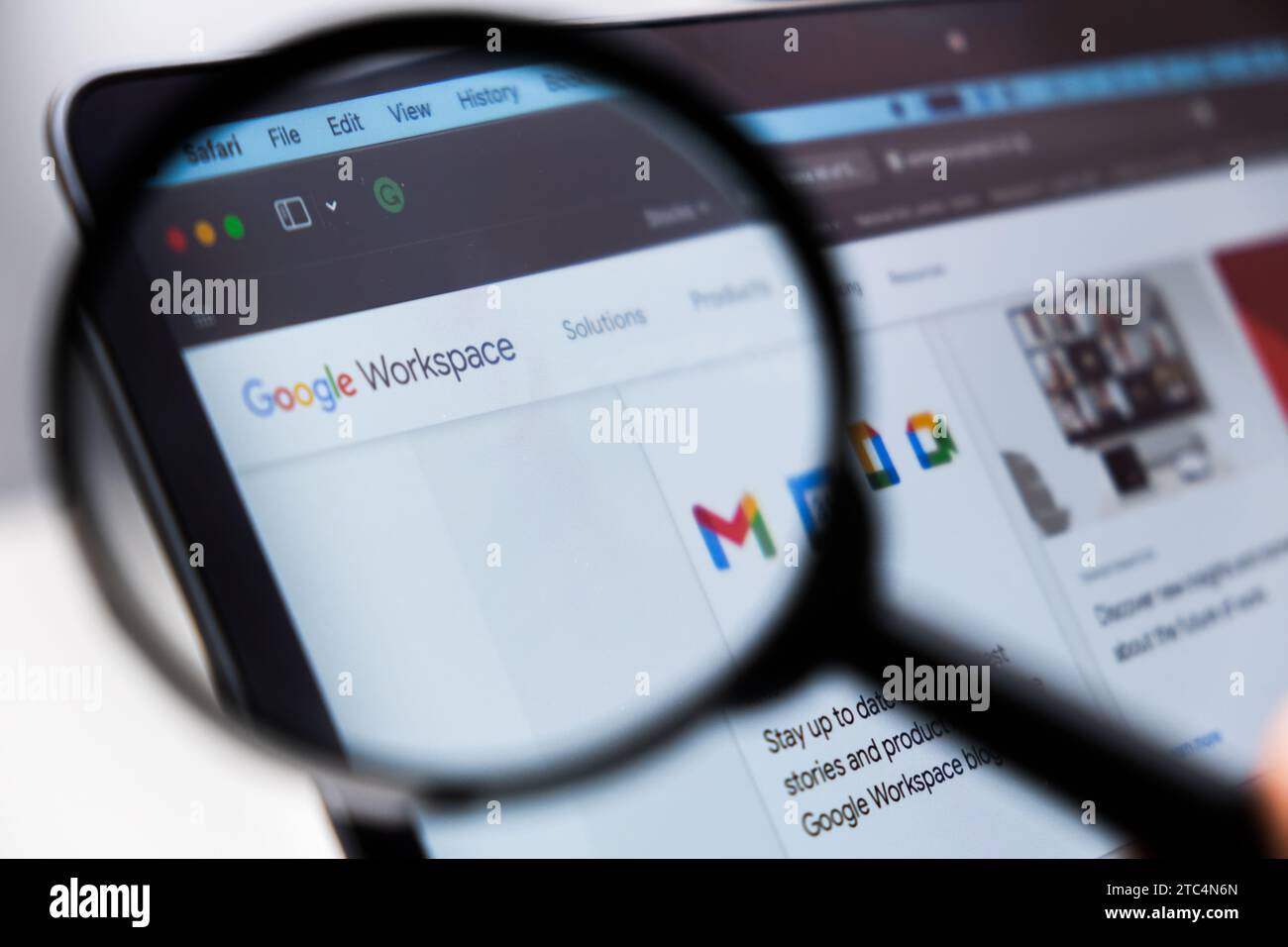 Google Workspace logo enlarged through a magnifying glass on a laptop ...