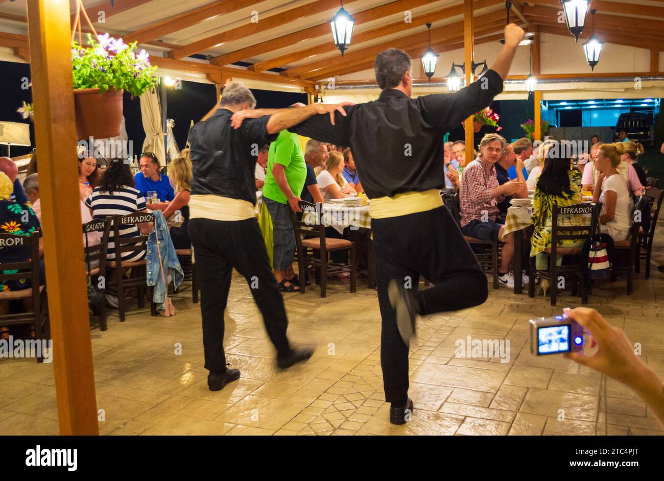 Greek dancers performing traditional dance at a restaurant Nydri ...