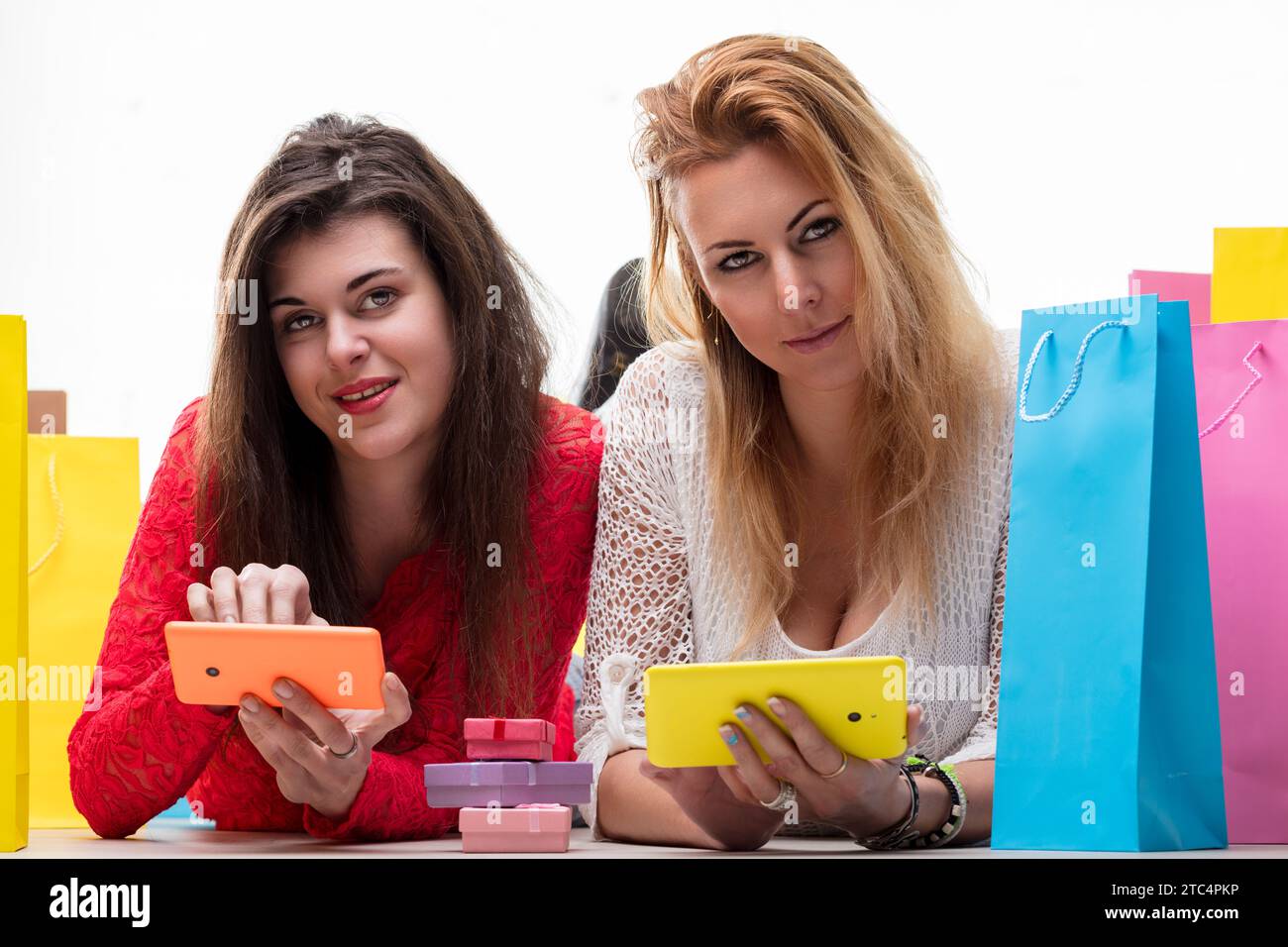 Content after a day of shopping, two women share a moment of digital ...
