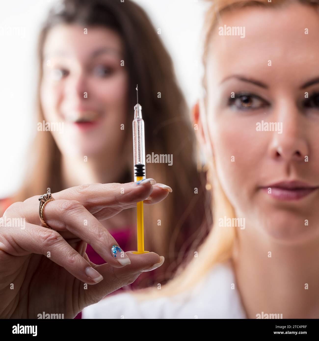 Syringe examination by a healthcare worker, observed by an apprehensive ...