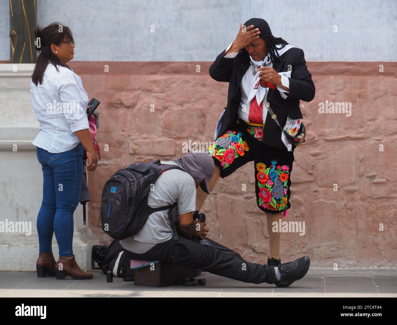 Shoe shiner attending to a folkloric dancer before an indigenous ...