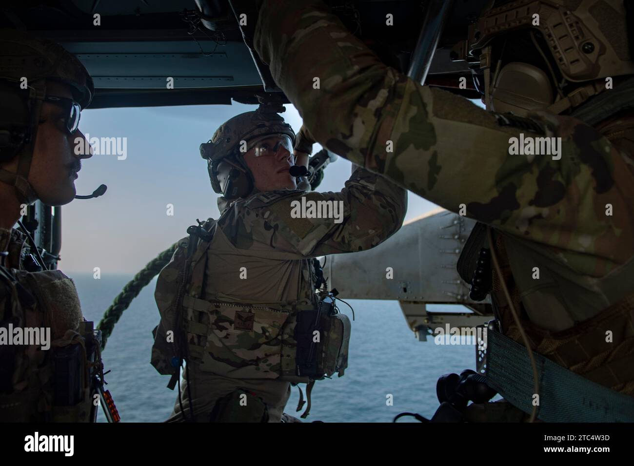 U.S. Navy Explosive Ordnance Disposal Technicians prepare to descend a ...