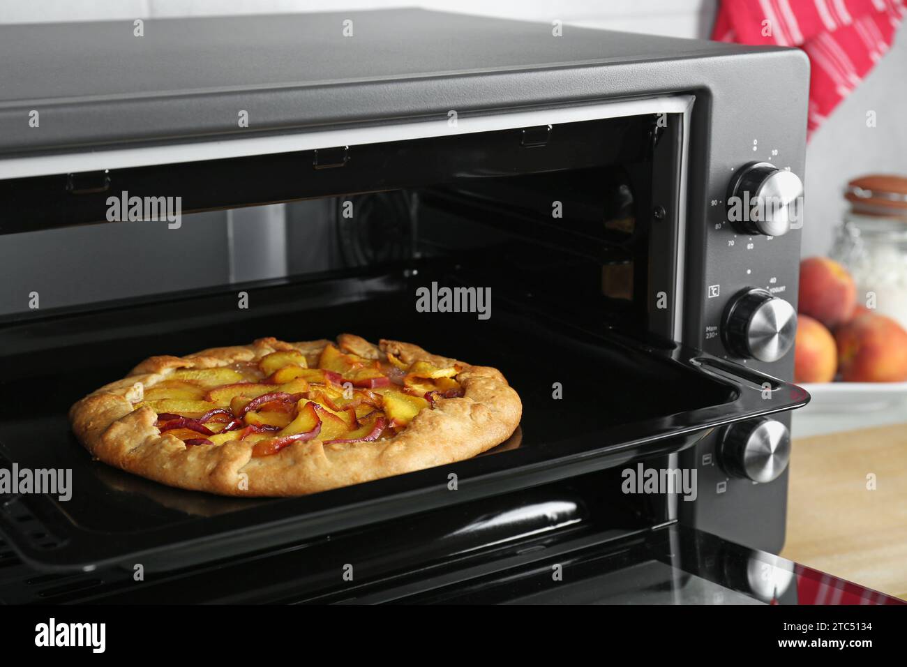 Open electric oven with delicious pie on table Stock Photo - Alamy