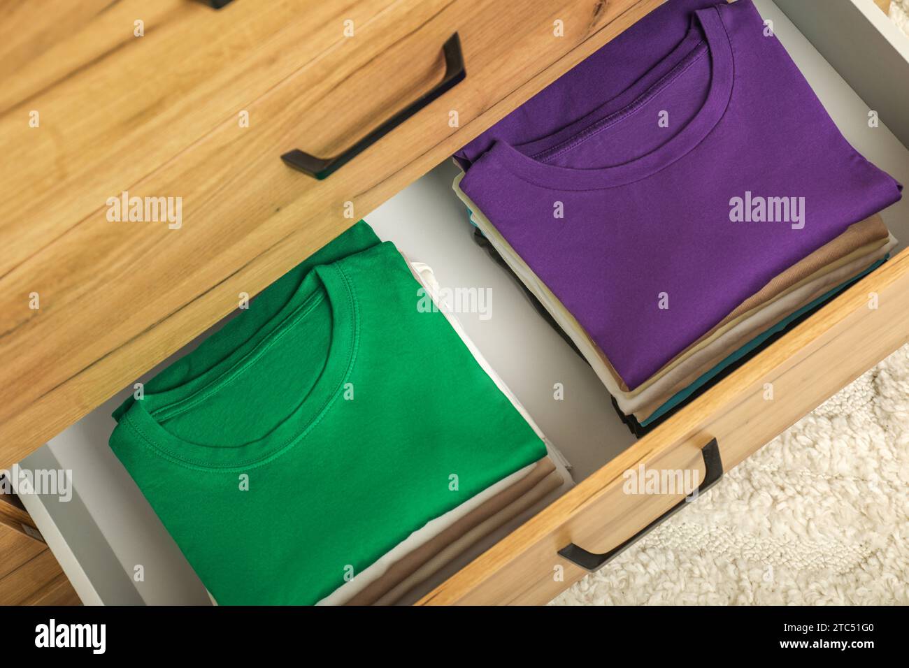 Stacks of different folded shirts in drawer indoors, top view ...