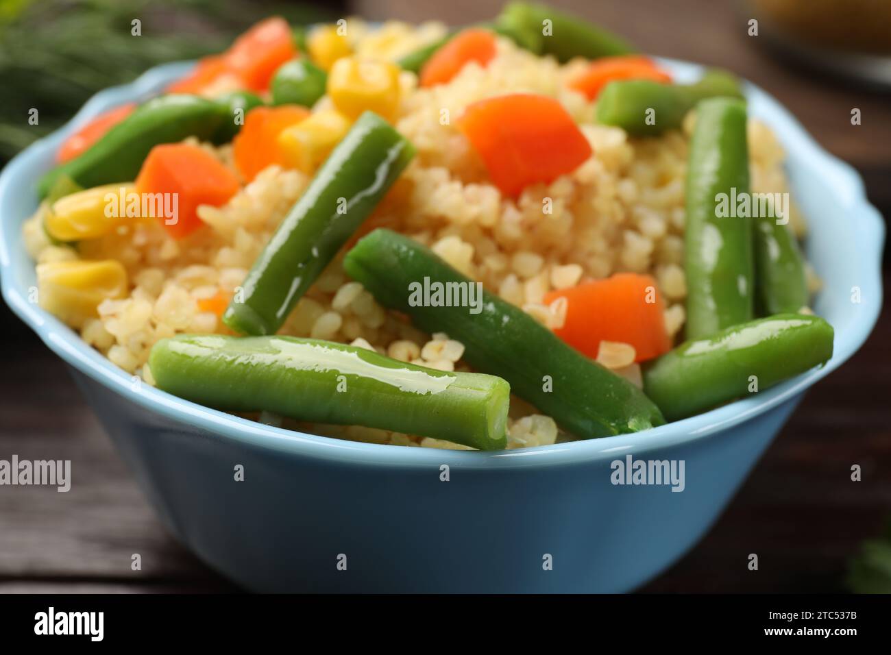 Delicious bulgur with vegetables in bowl on table, closeup Stock Photo ...