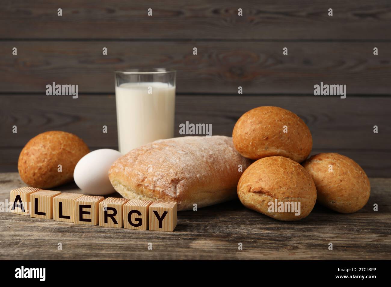 Food allergy. Bread, milk, egg and cubes on wooden table Stock Photo ...