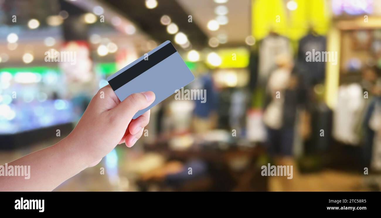 Female hand holding credit card with shopping mall background Stock ...