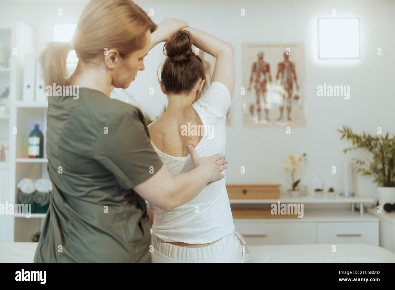 Healthcare time. massage therapist woman in massage cabinet with client doing checkup Stock ...